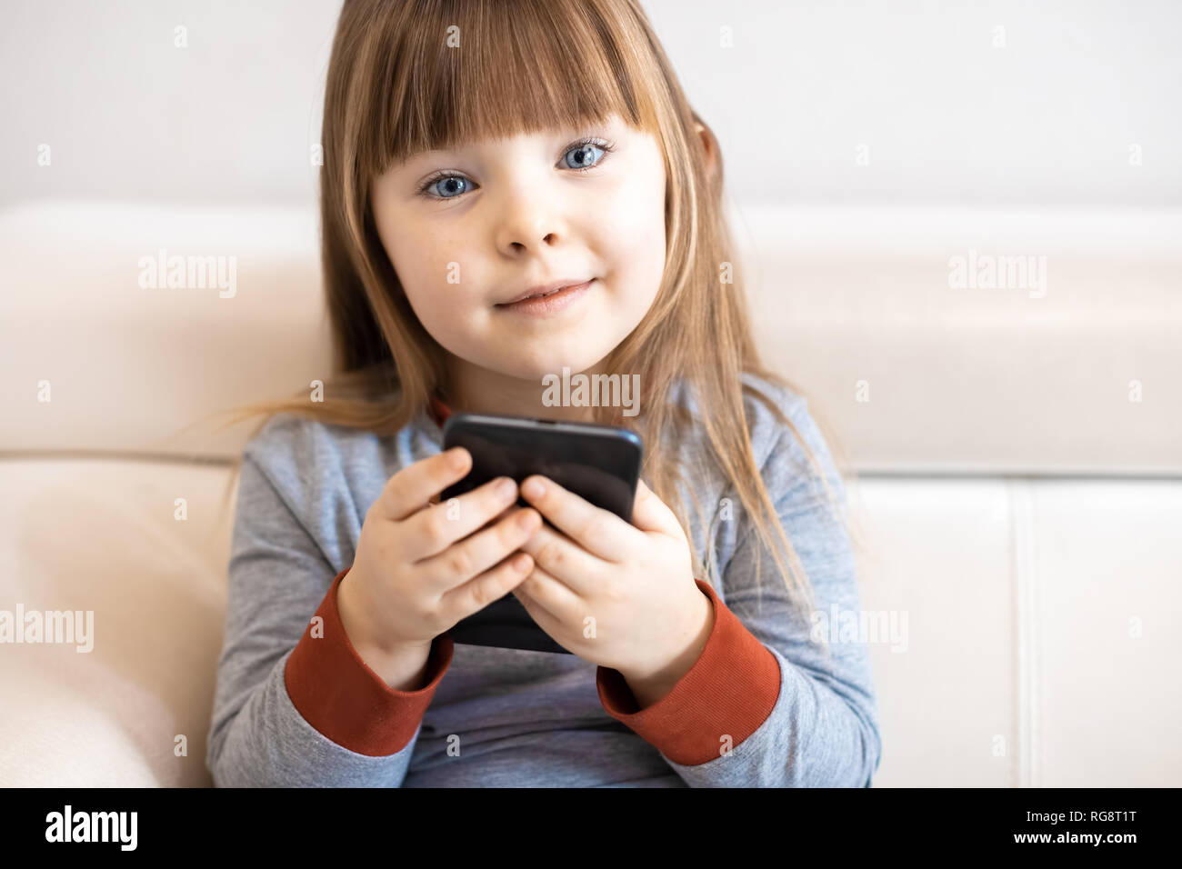 Cute little girl using smart phone Stock Photo - Alamy