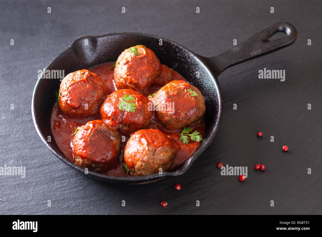 Food Homemade organic spicy meatball in iron cast on black slate stone ...