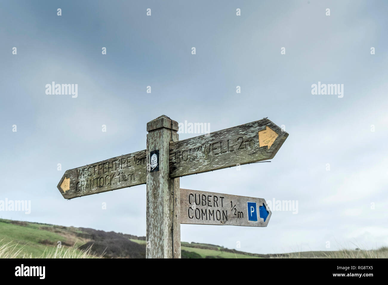 A wooden signpost giving directions for the South West Coast Path at ...