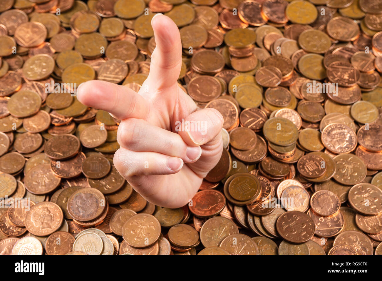 The hand which is sticking out of heap of coins Stock Photo - Alamy