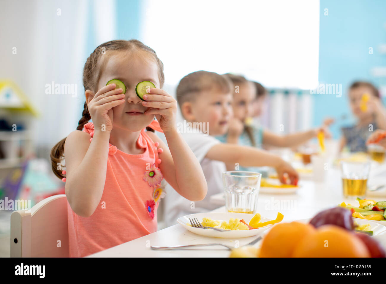 Funny kid eating healthy food in kindergarten or daycare Stock Photo ...