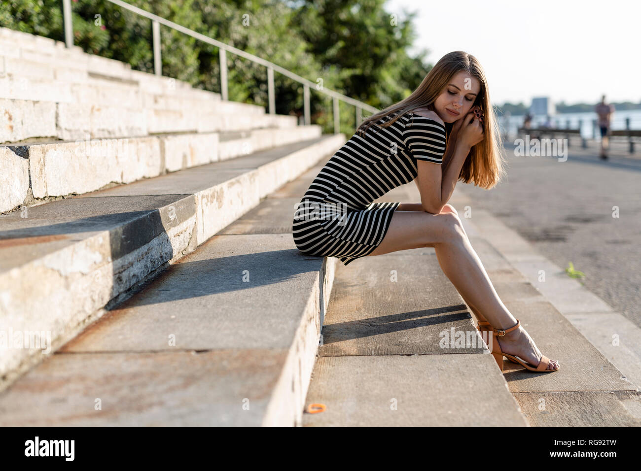 Young woman sitting stairs sunset hi-res stock photography and images - Alamy