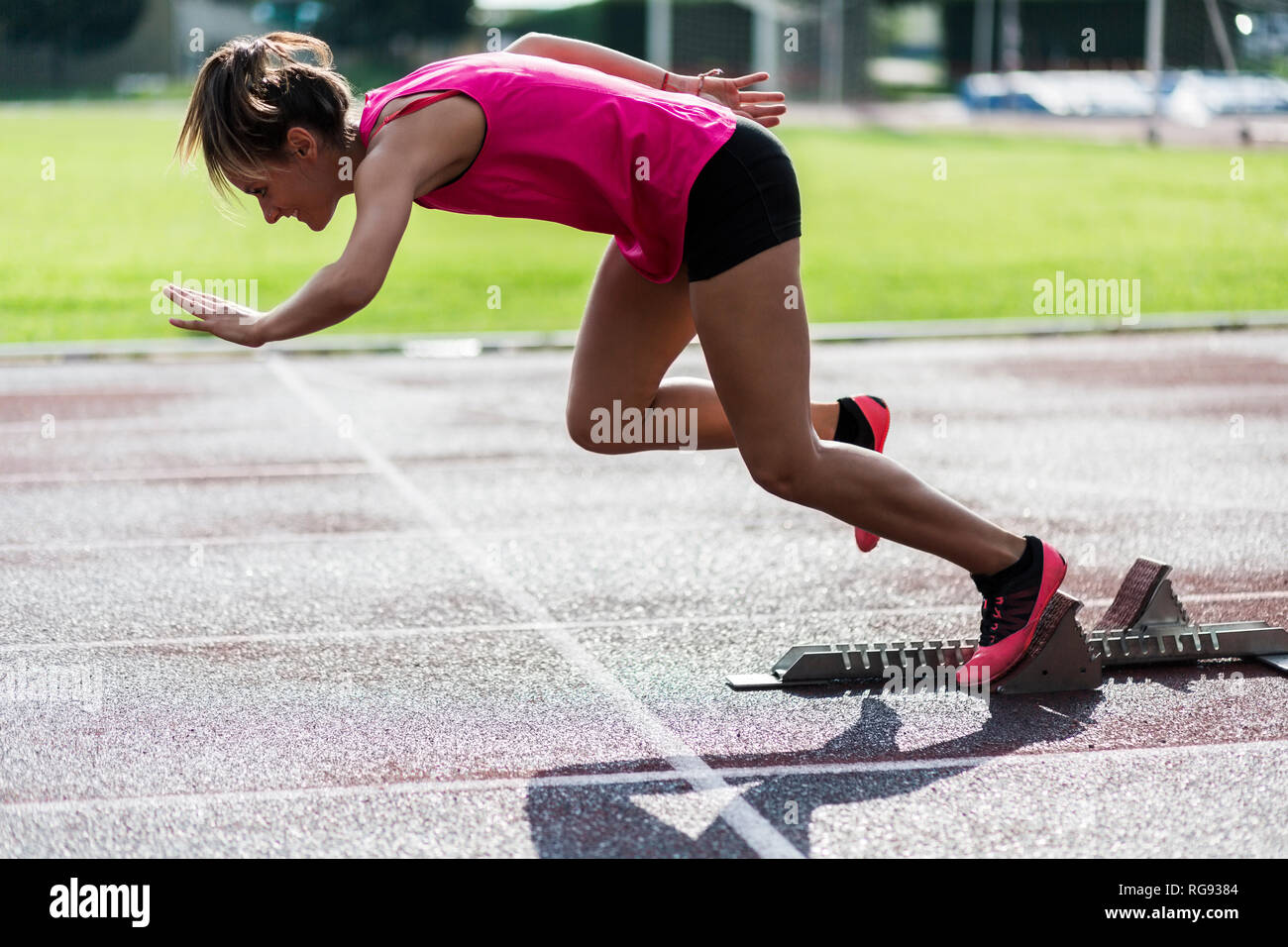 Teenage runner training start on race track Stock Photo - Alamy
