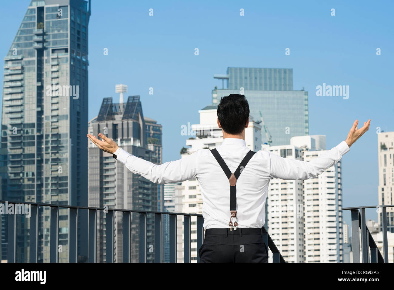 Happy and content successful business man on city rooftop Stock Photo ...