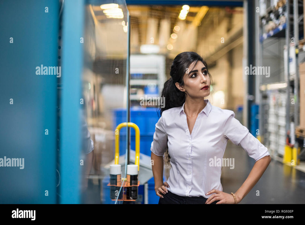 Woman in factory storehouse looking around Stock Photo - Alamy