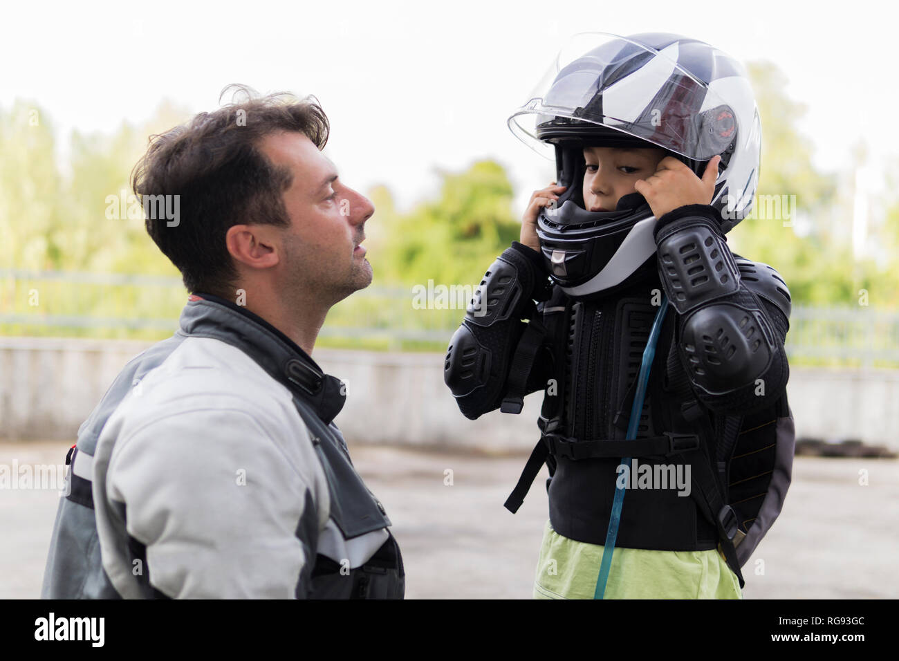 Father watching son putting motorcycle helmet hi-res stock photography ...