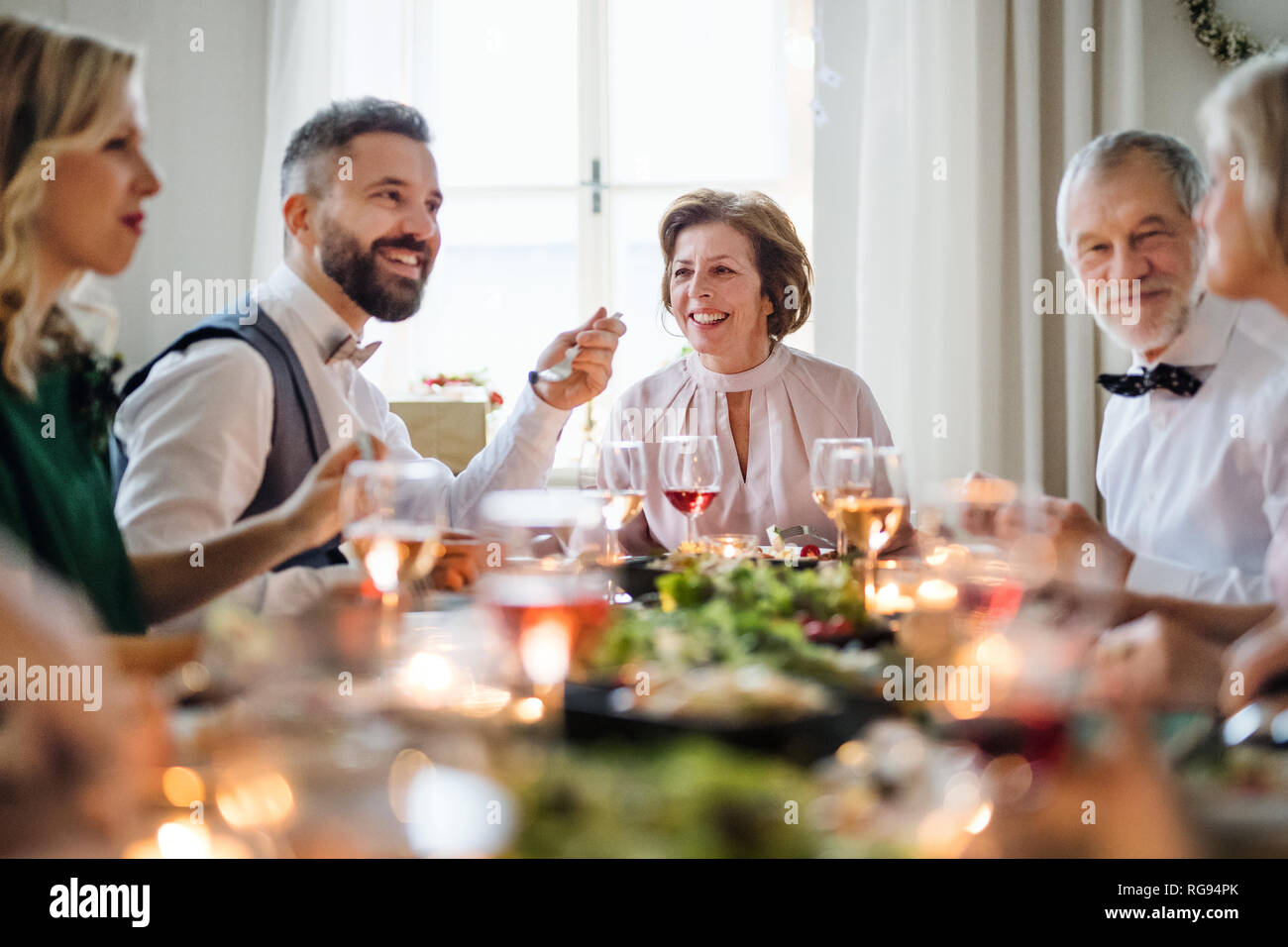 A happy big family sitting at a table on a indoor birthday party ...