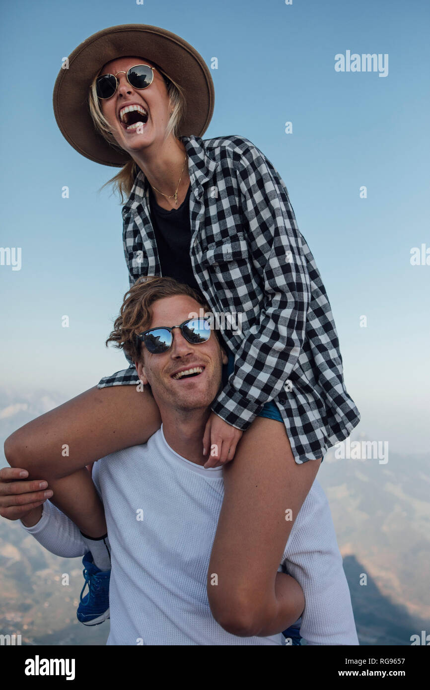 Happy young man carrying girlfriend piggyback Stock Photo - Alamy