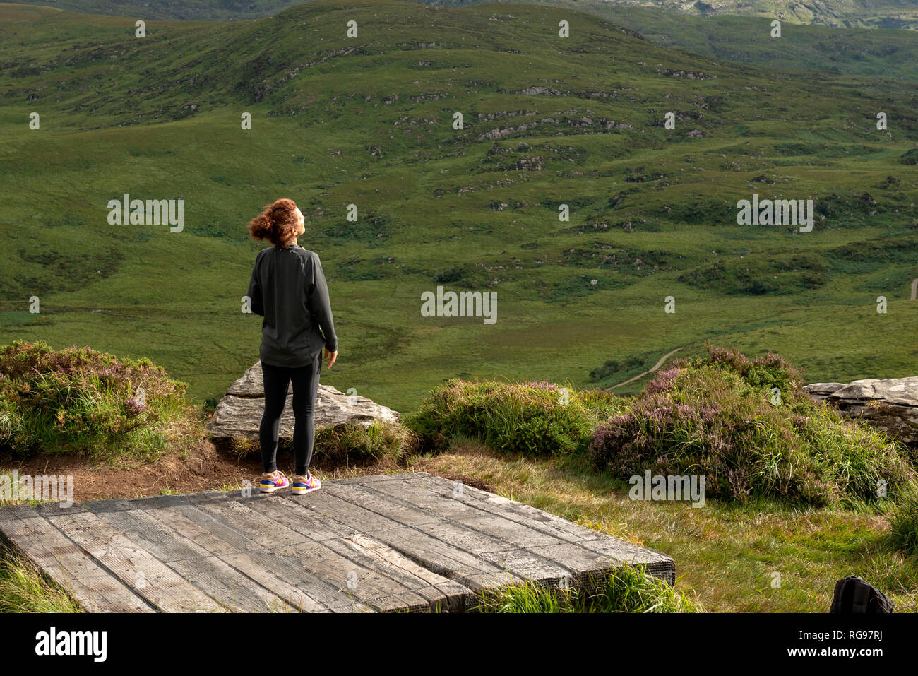 Young female hiker on viewing platform admiring the scenic view to the ...