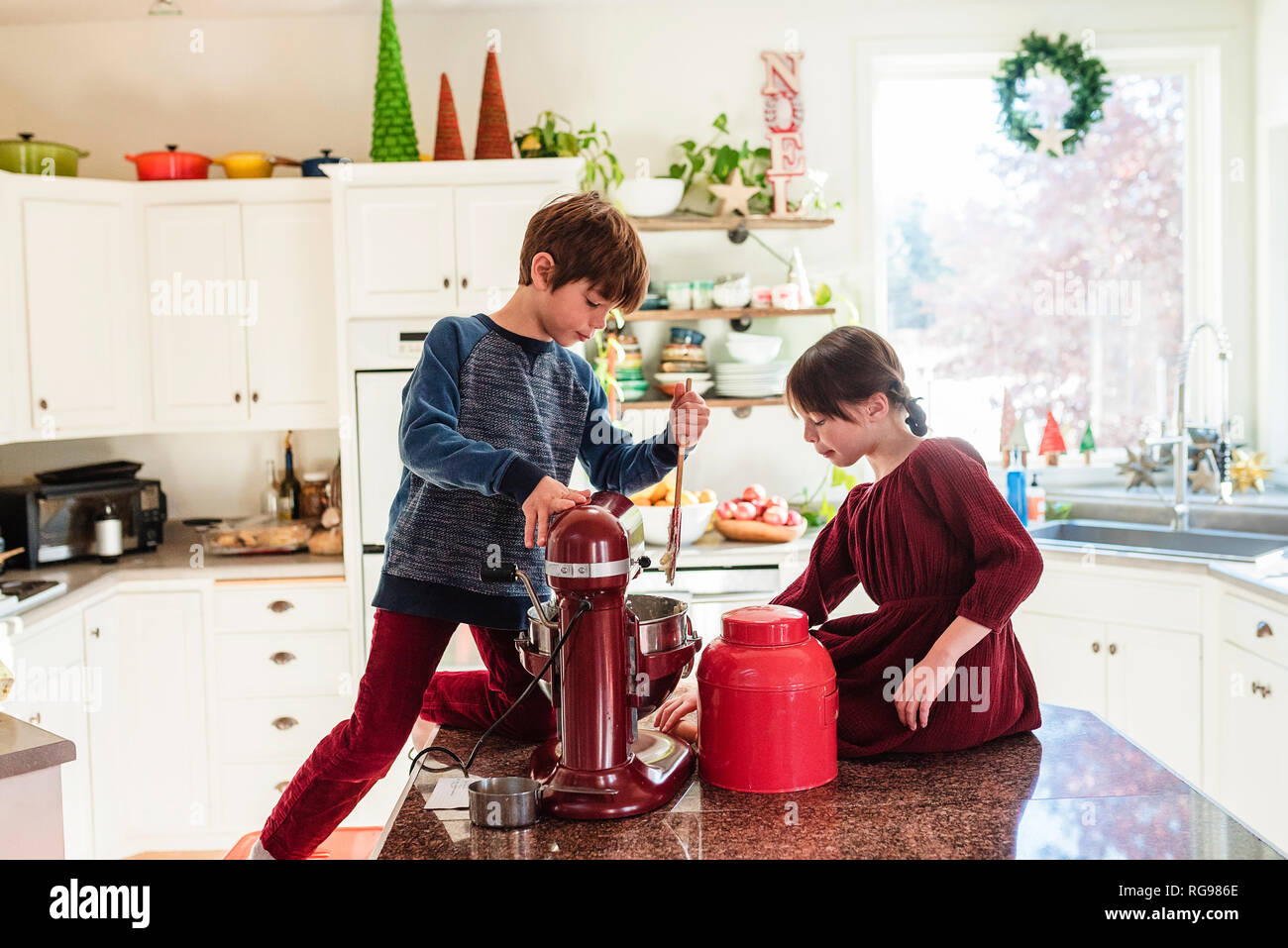 Two children in the kitchen making a cake Stock Photo - Alamy