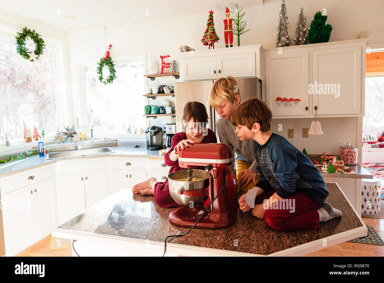 Three children in the kitchen making a cake Stock Photo - Alamy