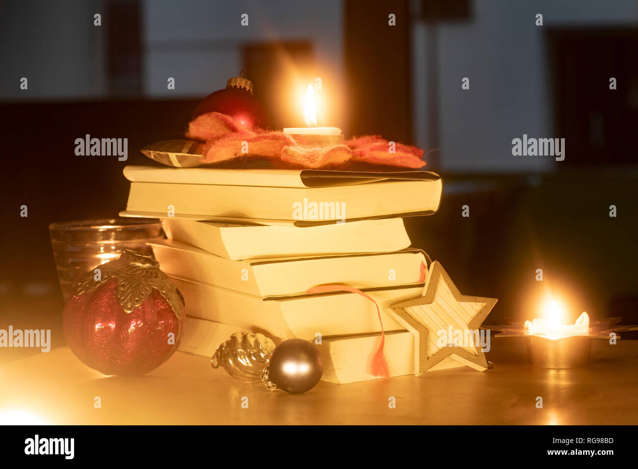 Stack of books with a candle and Christmas baubles Stock Photo - Alamy