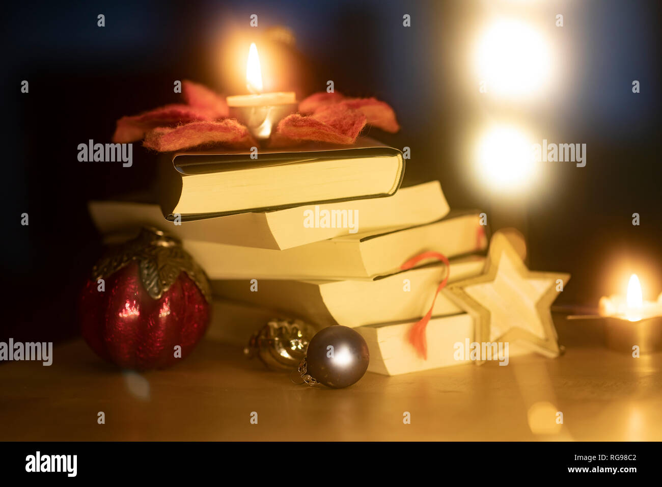 Stack of books with a candle and Christmas baubles Stock Photo - Alamy