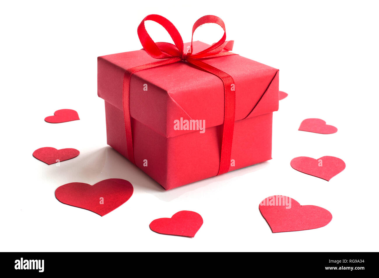 Small red gift box with ribbon bow and paper hearts studio isolated on ...