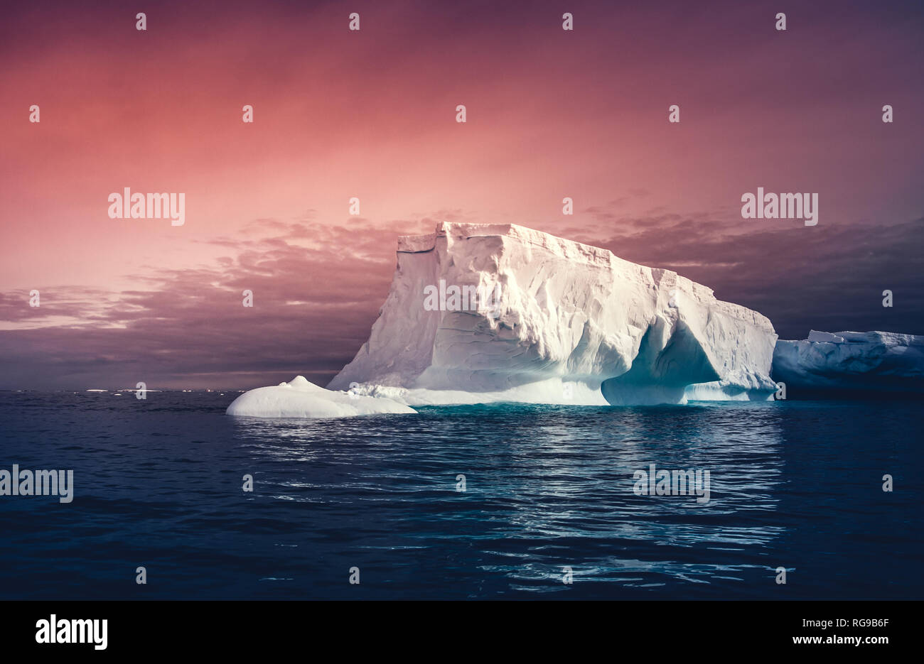 The huge iceberg on the colorful sunset sky background. Breathtaking ...