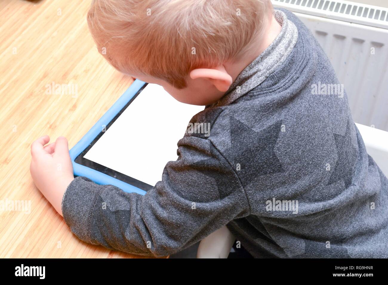 Child using a tablet device to learn and play games, model is young boy ...