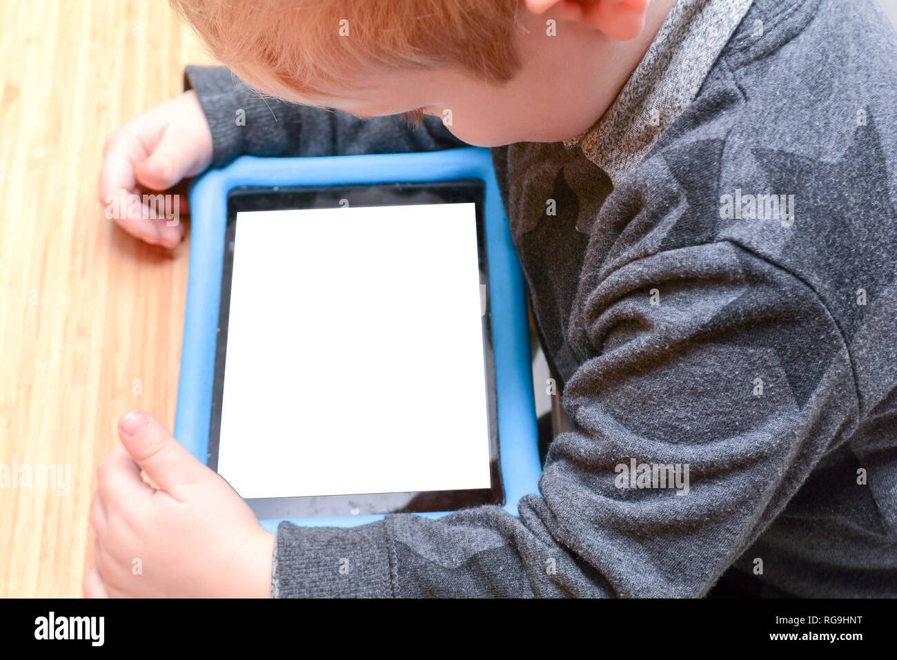 Child using a tablet device to learn and play games, model is young boy ...