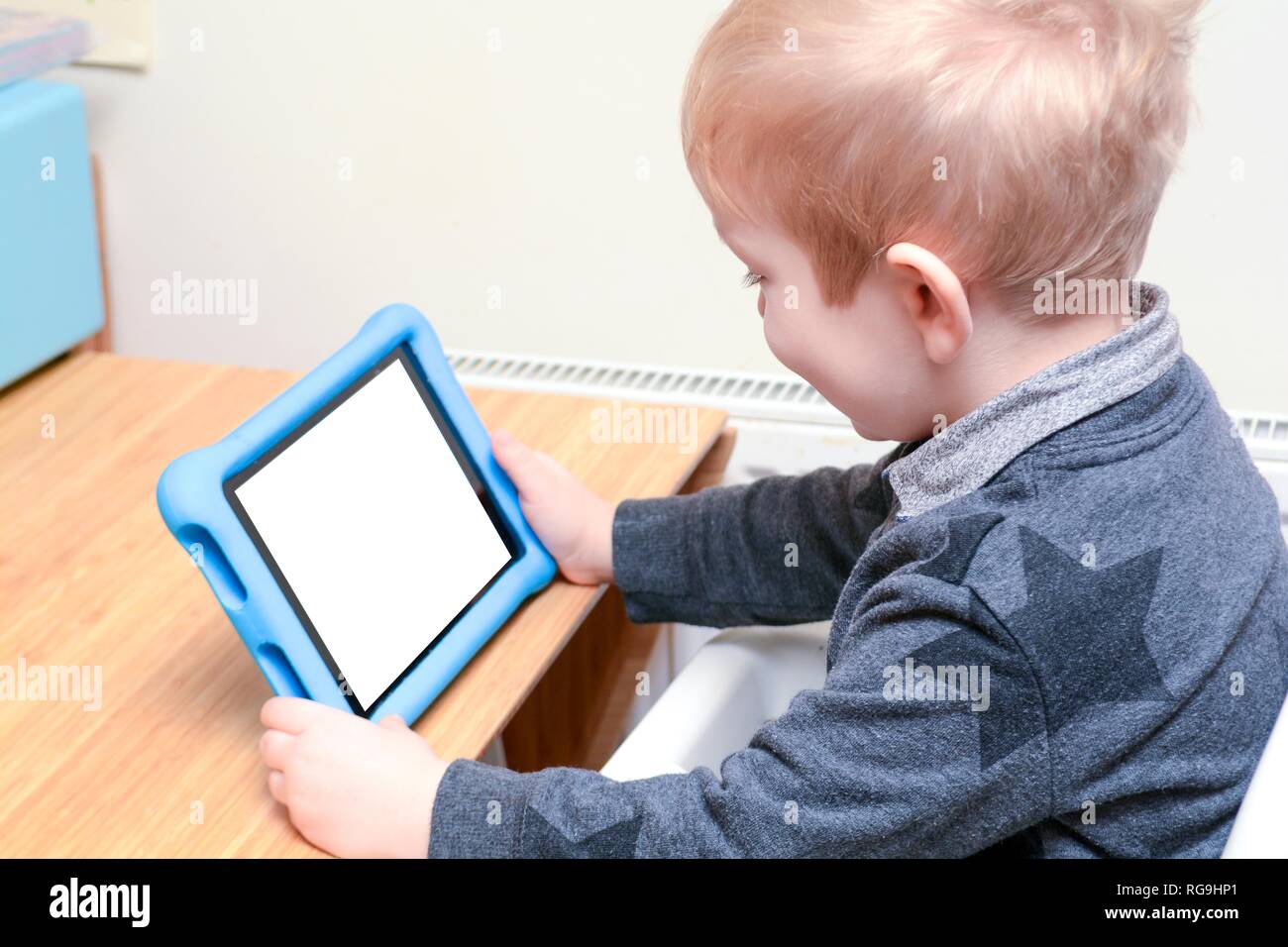 Child using a tablet device to learn and play games, model is young boy ...