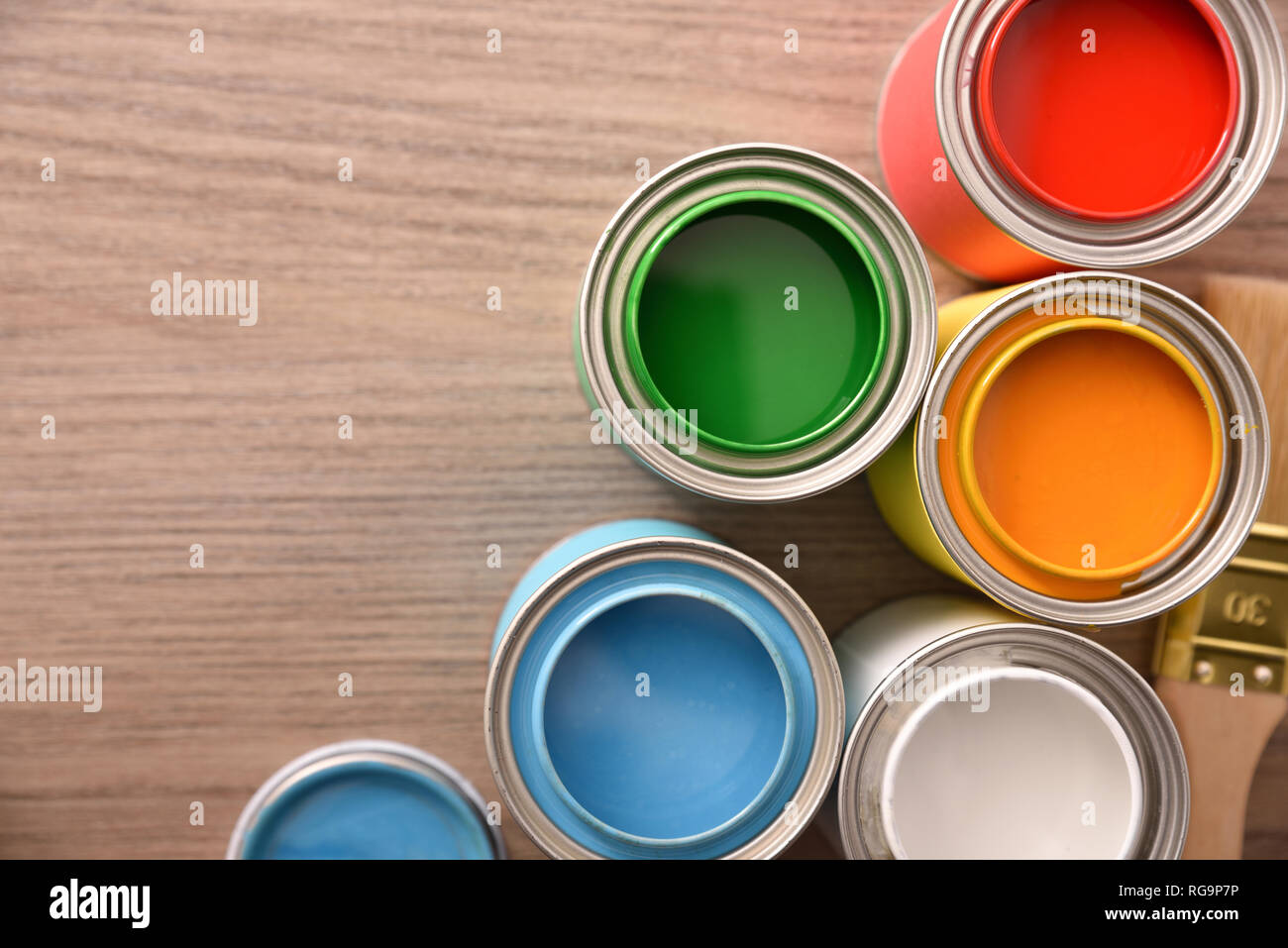 Five open paint cans on wooden table close up. Top view. Horizontal ...