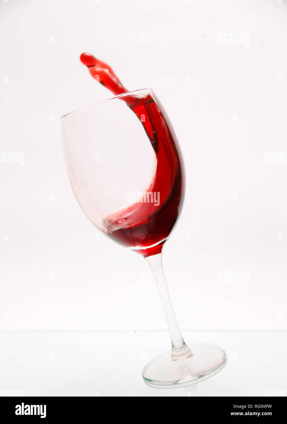 A glass of splashing red wine Stock Photo - Alamy