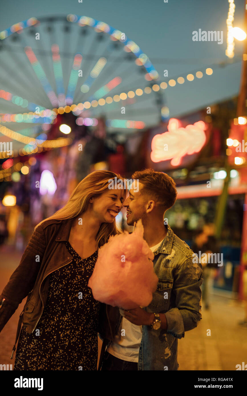 Romantic couple at a funfair eating candy floss Stock Photo - Alamy