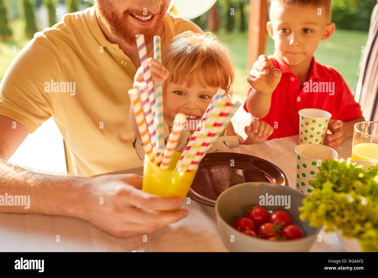 Children taking straws a garden party Stock Photo - Alamy