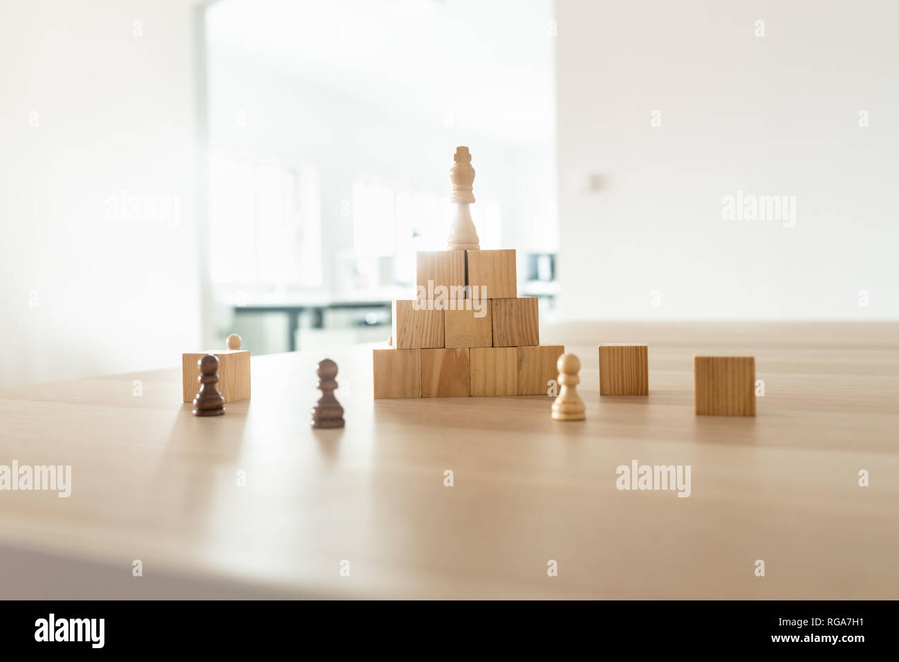Chess figure of king placed on top of pyramid made of wooden blocks in ...