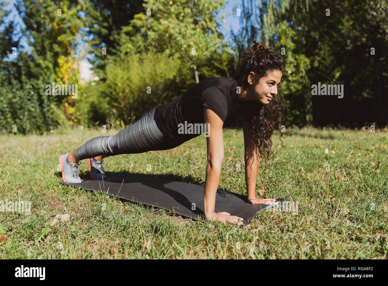 Sporty young woman doing push-ups on a meadow Stock Photo - Alamy