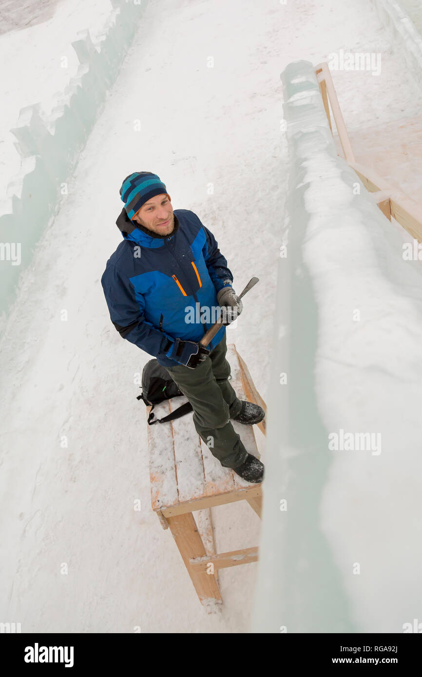 The sculptor cuts an ice figure out of an ice block with a chisel Stock ...