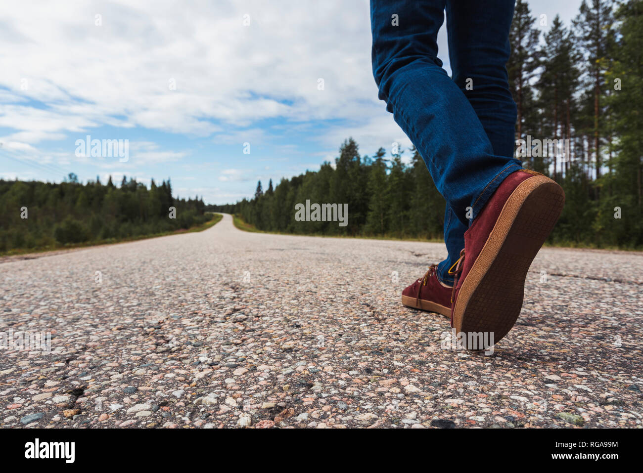 Finland, Lapland, feet of man walking on empty country road Stock Photo ...