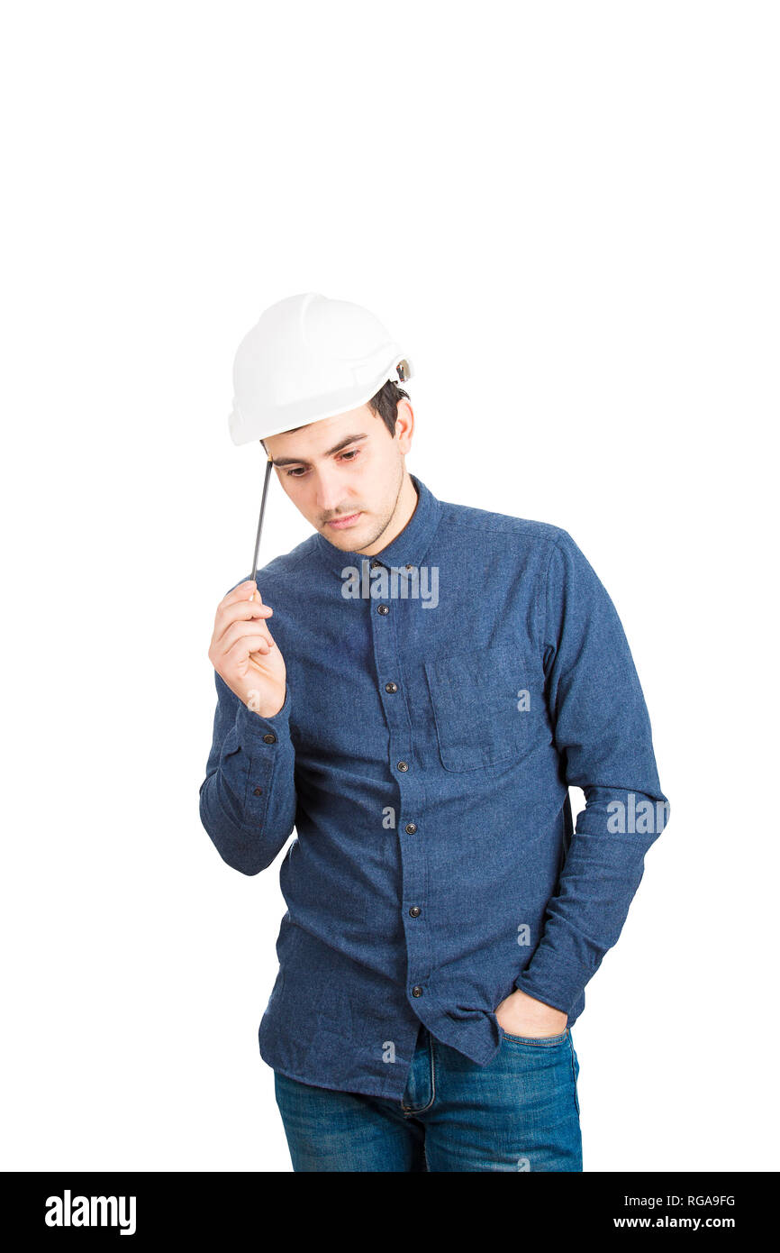 Thoughtful young man engineer wearing protective helmet thinking ...