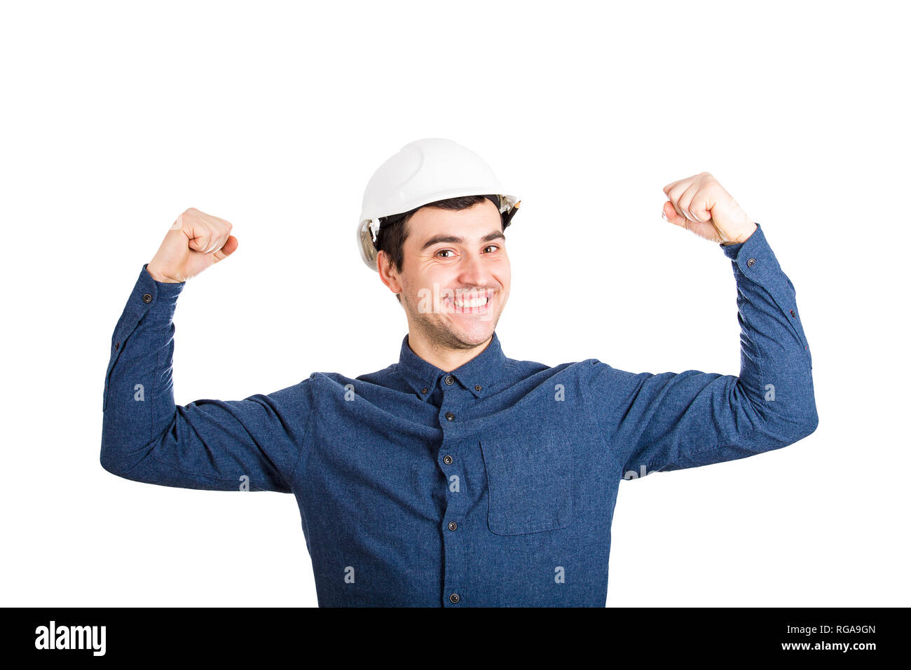 Powerful young man engineer wearing protective helmet looking to camera ...
