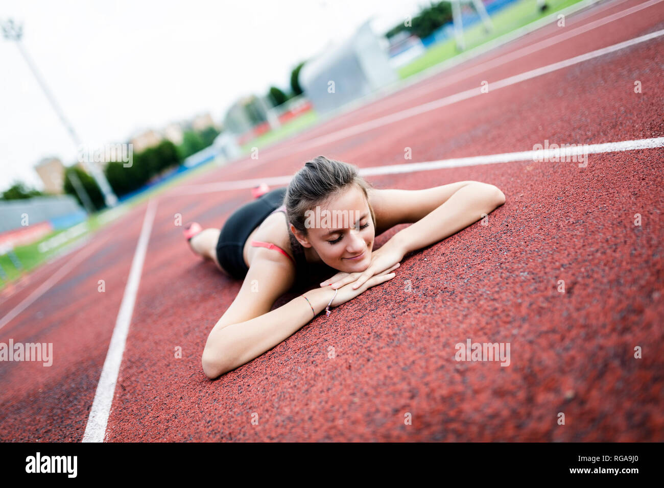 Teenage runner relaxing on race track, after training Stock Photo - Alamy