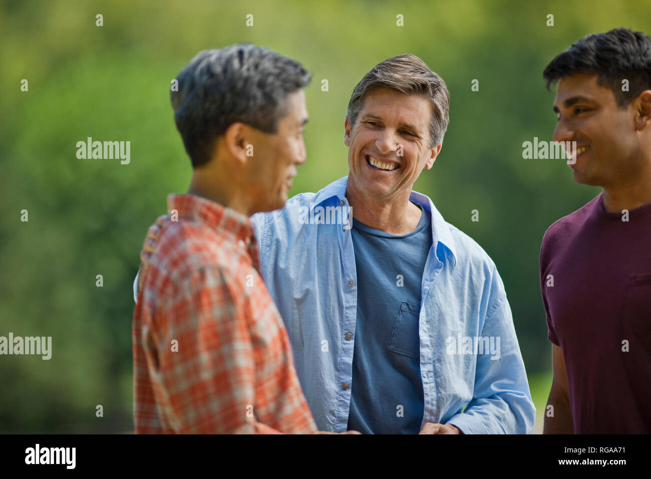 Three friends talking and laughing together Stock Photo - Alamy