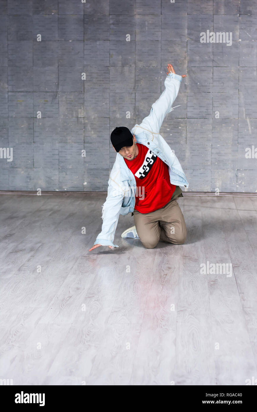 Young handsome dancer on floor. Stylish rap dancer in dynamic pose on ...
