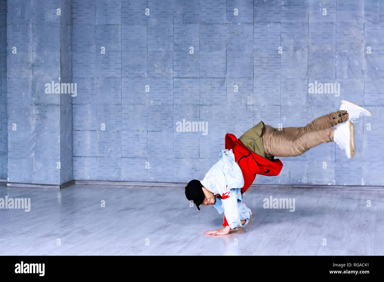 Young man standing on hands in dance. Fashion style dancer raised his ...