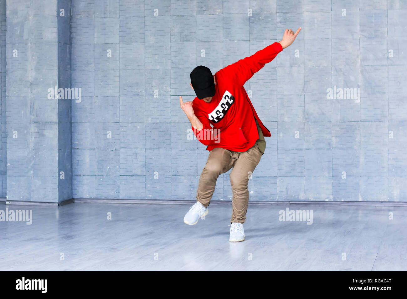 Active young dancer in movement. Young stylish guy dancing on grey ...