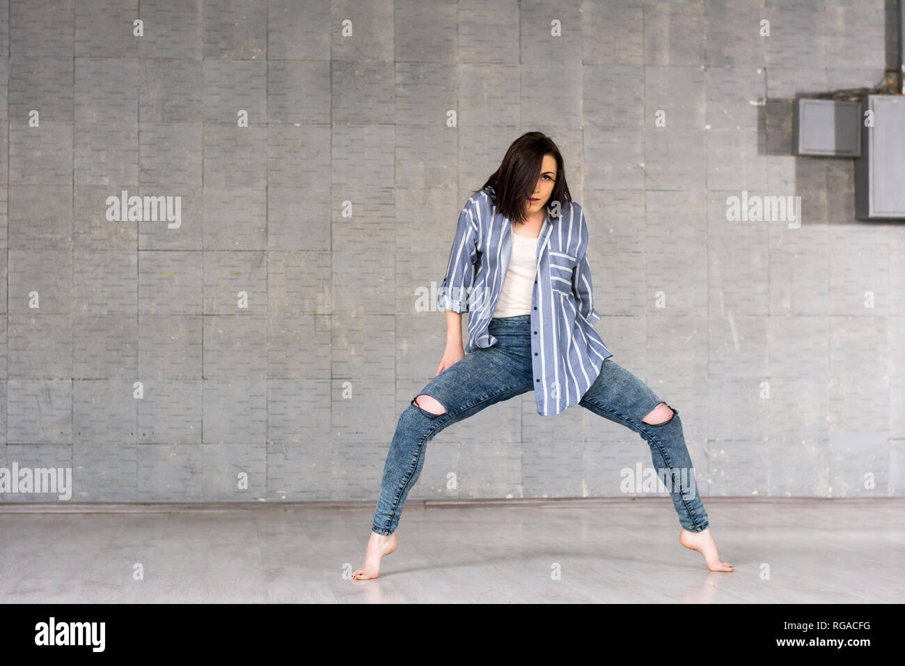 Modern style girl posing on grey background. Young pretty dancer woman ...