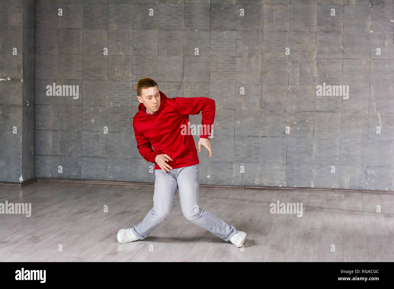 Young stylish rap performer is dancing. Young boy wearing jeans and red ...