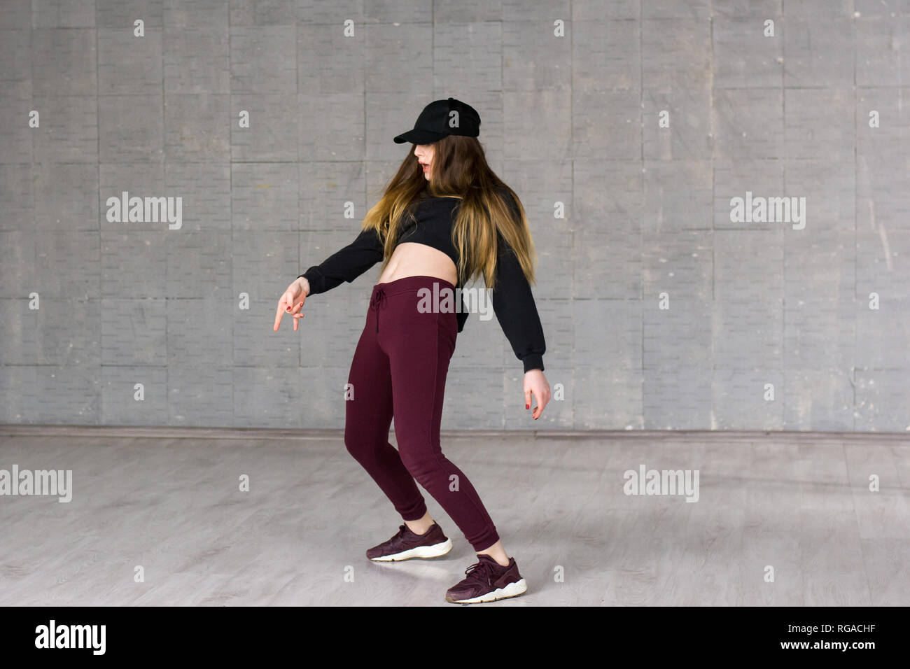 Modern style dancer is dancing. Young girl dancer posing on grey ...