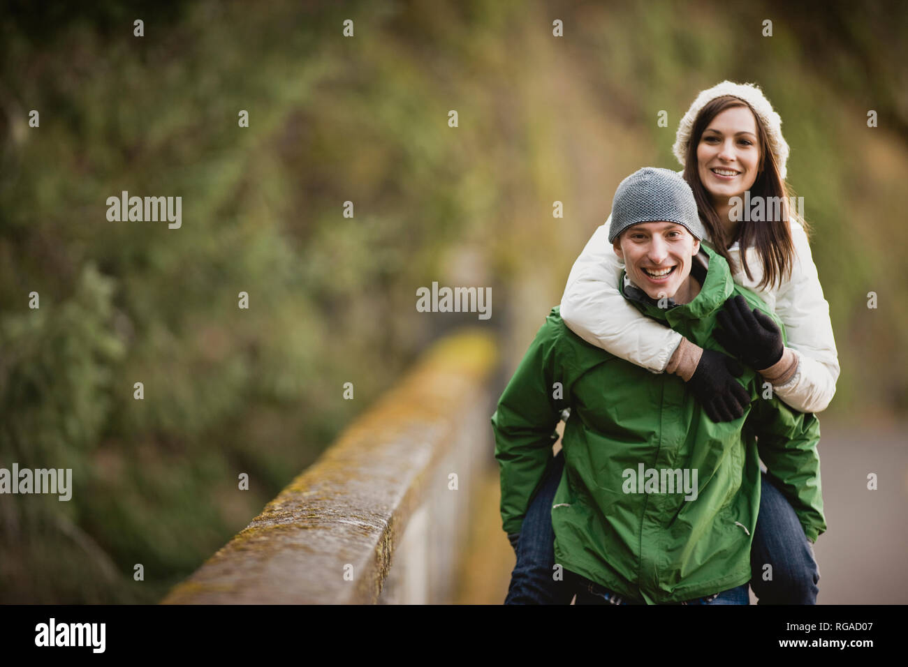 Man giving girlfriend a piggy-back ride Stock Photo - Alamy