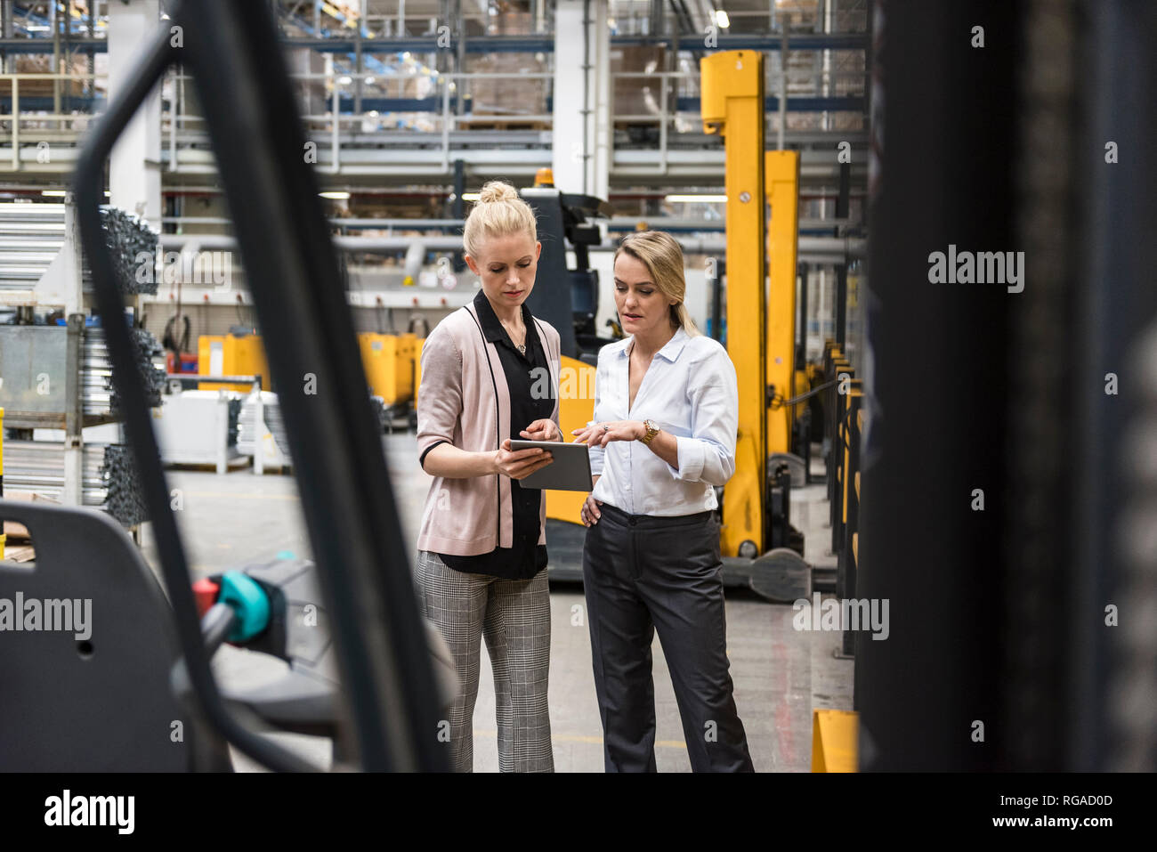 Two women with tablet talking in factory shop floor Stock Photo - Alamy