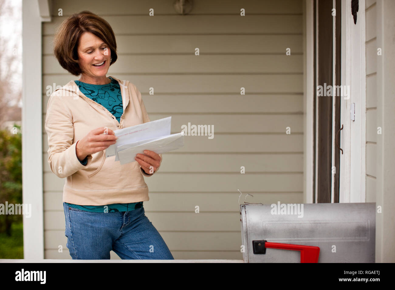 A woman checking her mailbox Stock Photo - Alamy