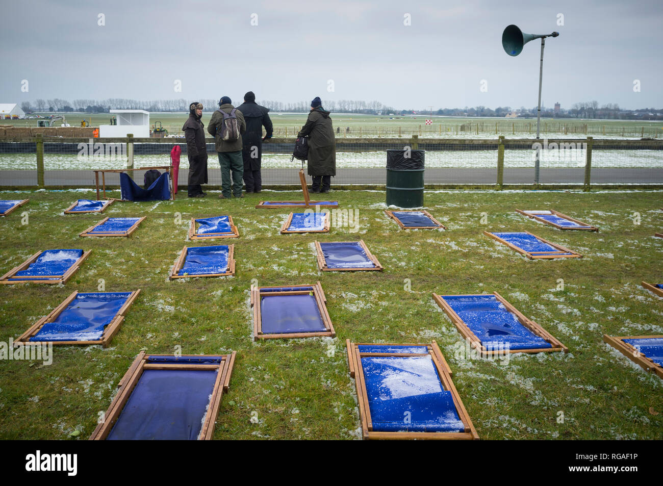 Spectators in freezing weather with deck chairs covered in ice and ...