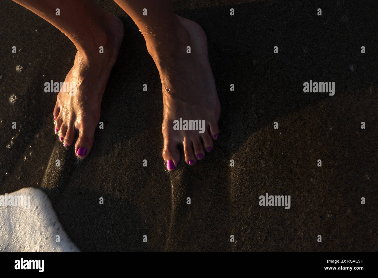 Feet washed by sea waves Stock Photo - Alamy
