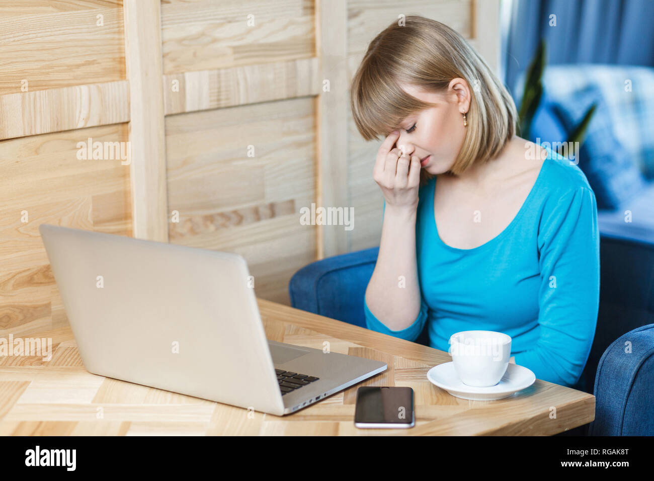 Side view portrait of sad young girl freelancer with blonde bob haircut ...
