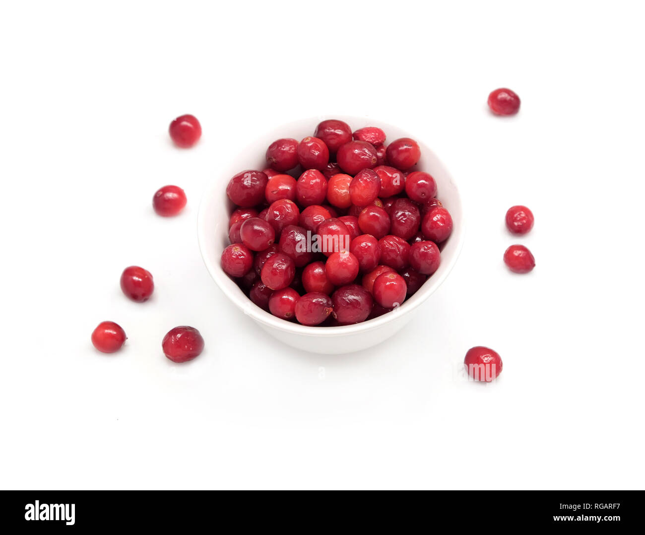 Cranberries in round white bowl and scattered berries isolated on white ...