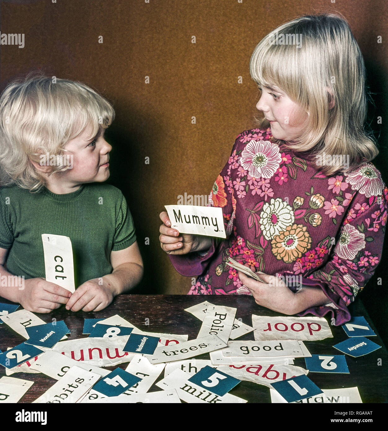 An older girl teaching her younger brother to read with the use of ...