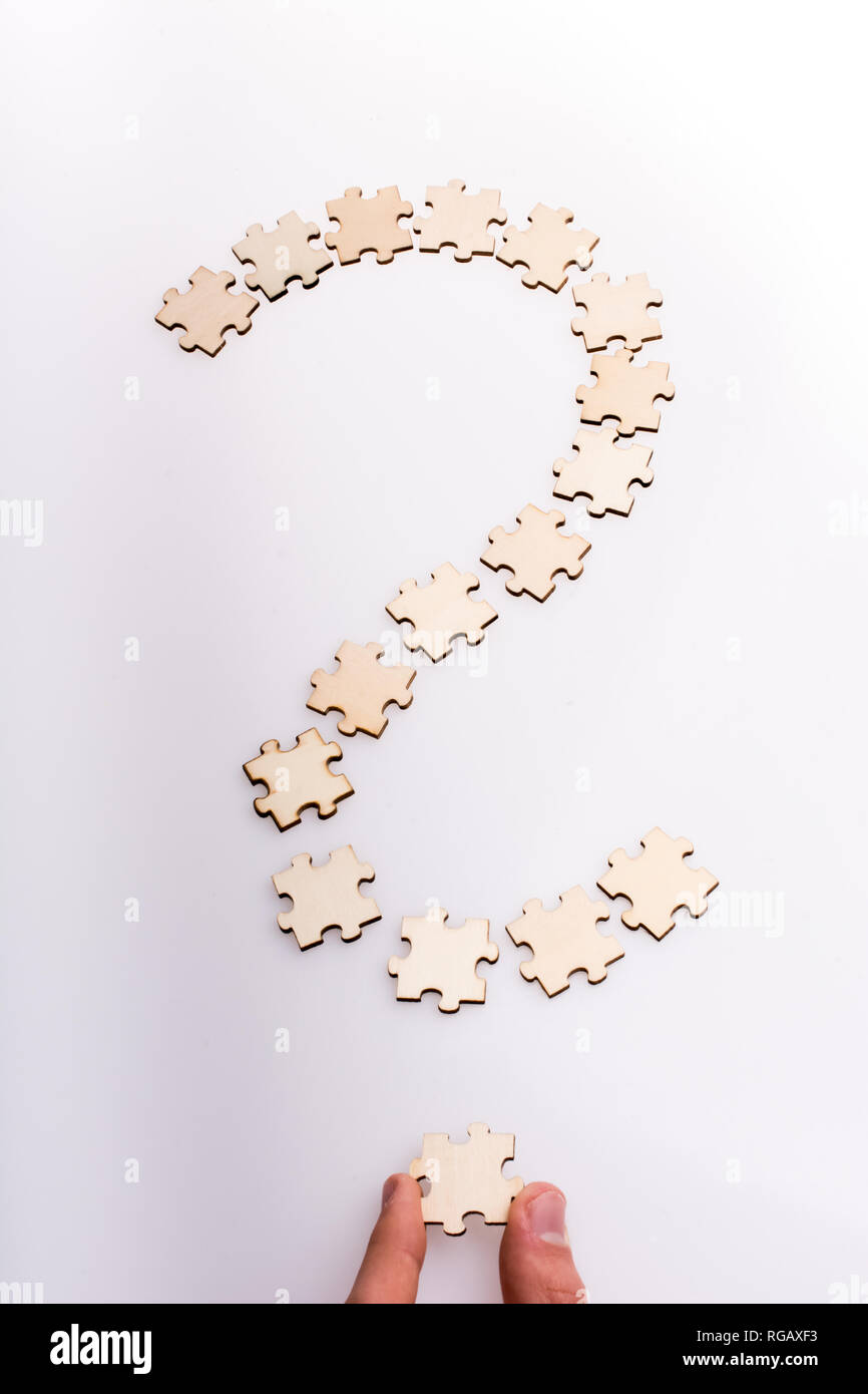 Hand holding the last piece of question mark. Question mark made from ...