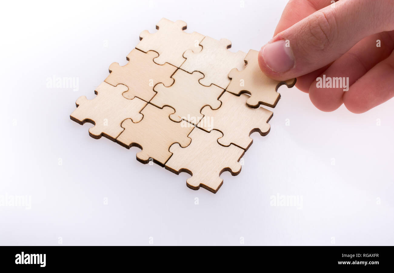 Hand completing a puzzle group on a white background Stock Photo - Alamy